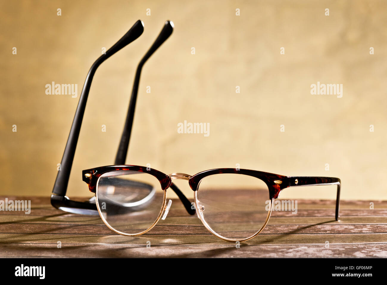two eyeglasses on the table with brown background Stock Photo - Alamy