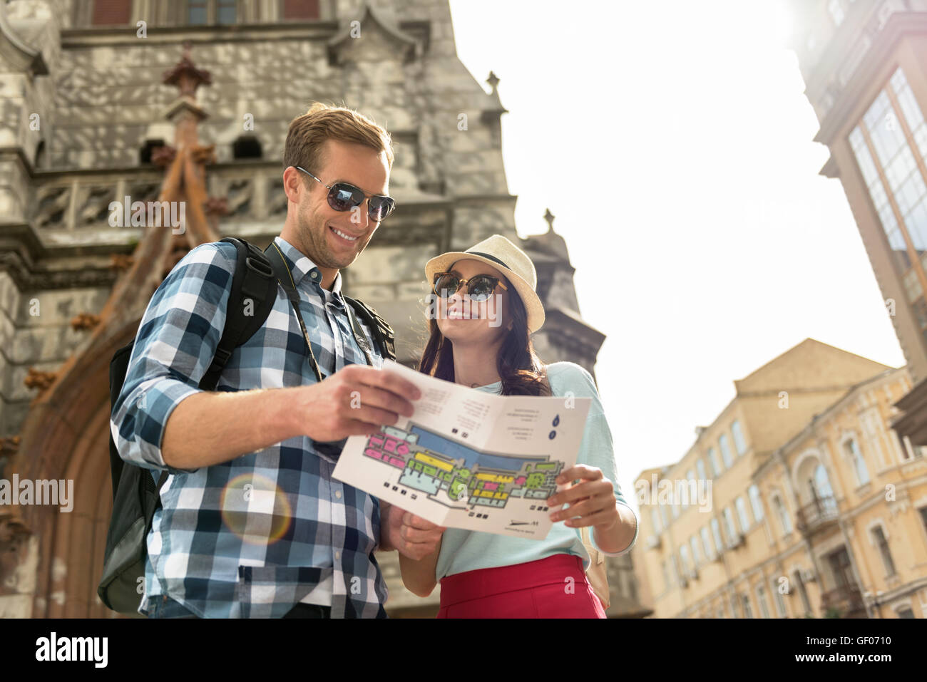 Positive tourists holding city map Stock Photo - Alamy