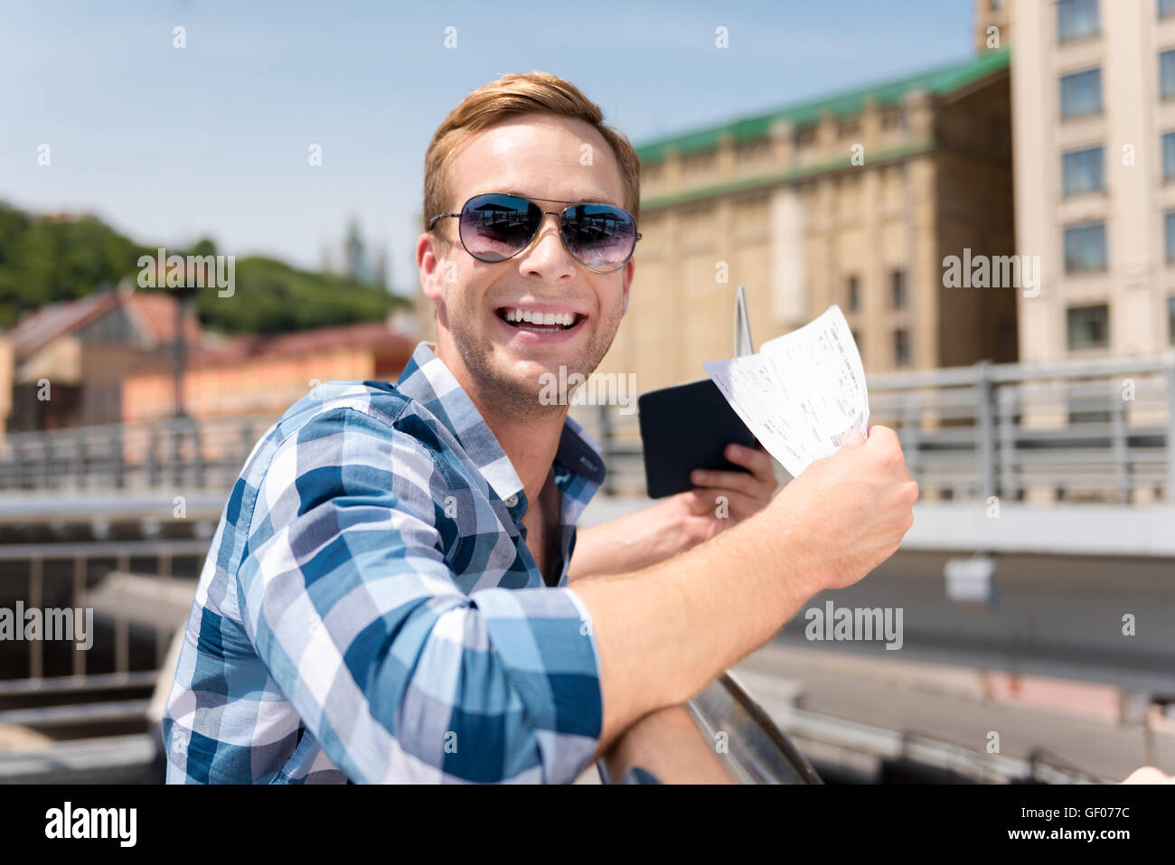 Positive man holding tickets Stock Photo - Alamy