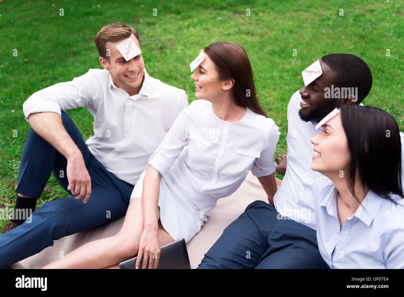 Cheerful smiling friends resting on the blanket Stock Photo - Alamy