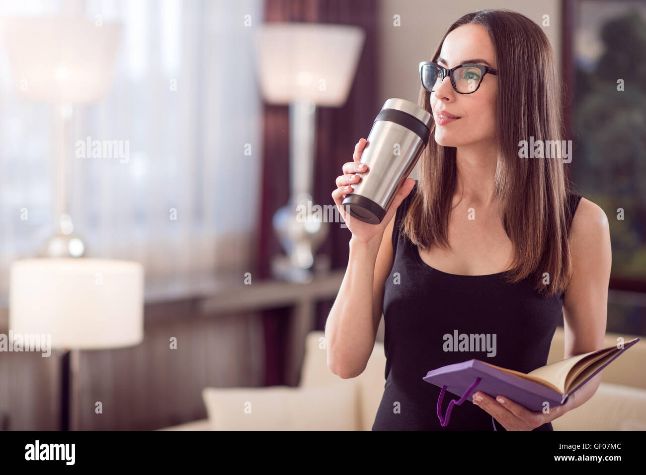 Woman dreaming and holding thermo mug Stock Photo - Alamy