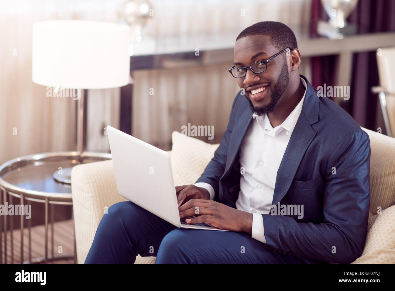 Man with laptop looking at camera Stock Photo - Alamy