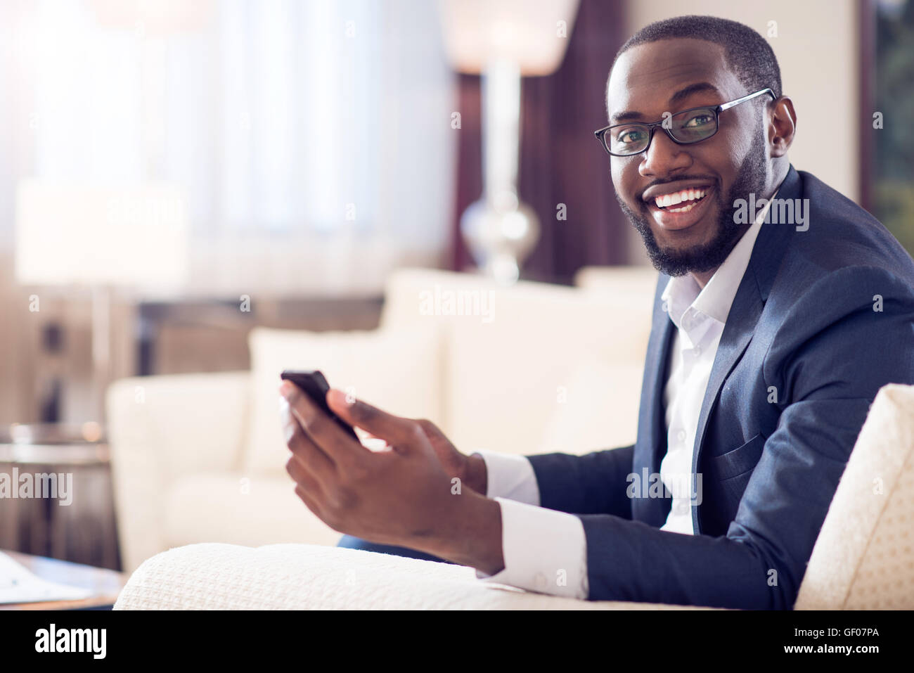 Man looking at camera and holding phone Stock Photo - Alamy