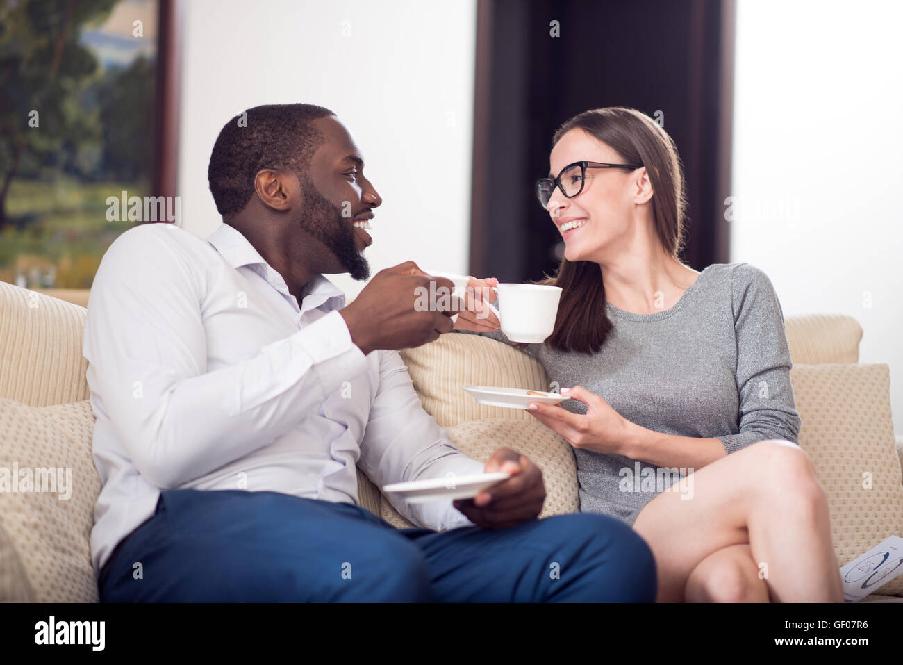 Smiling nice colleagues drinking coffee Stock Photo - Alamy