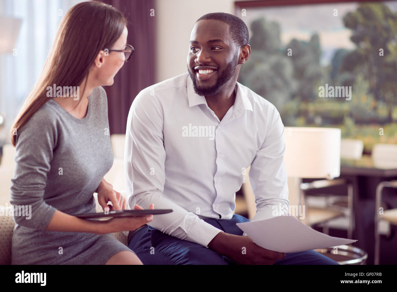 Man looking at woman while working Stock Photo - Alamy