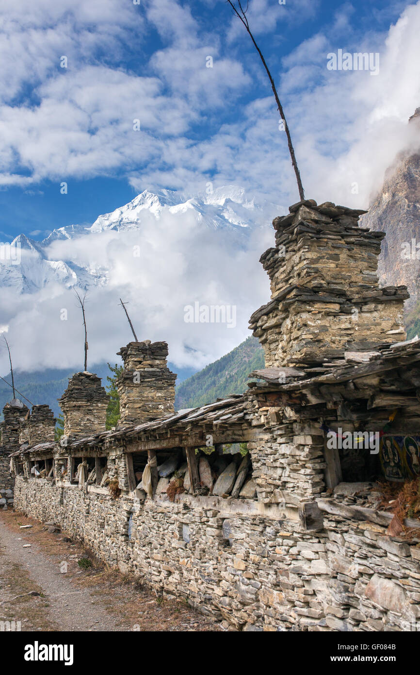 Buddhist prayer mani wall with prayer wheels in nepalese village on the ...