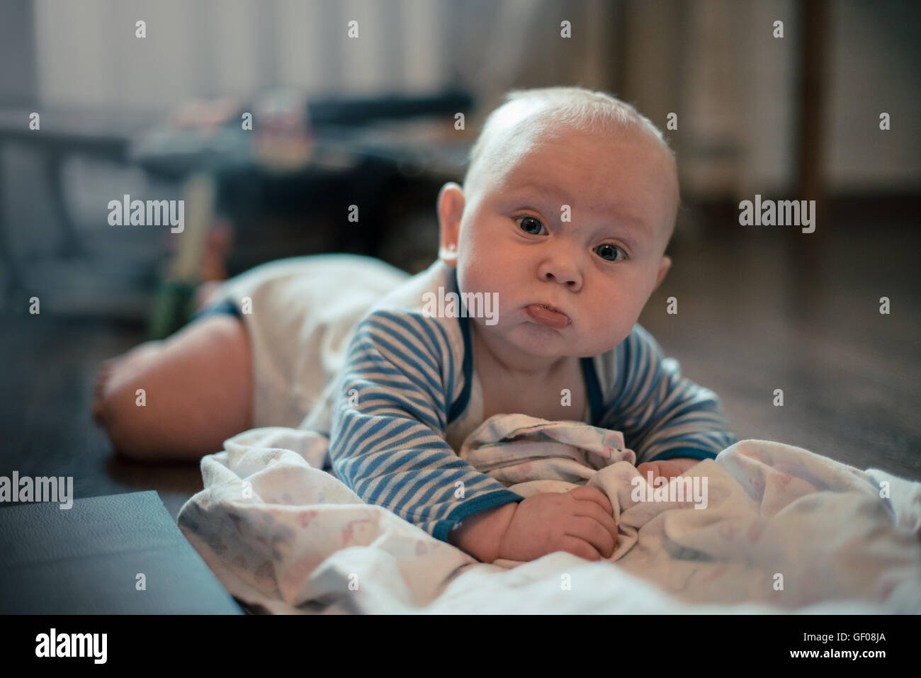 sullen child is lying on the wooden floor and playing Stock Photo - Alamy