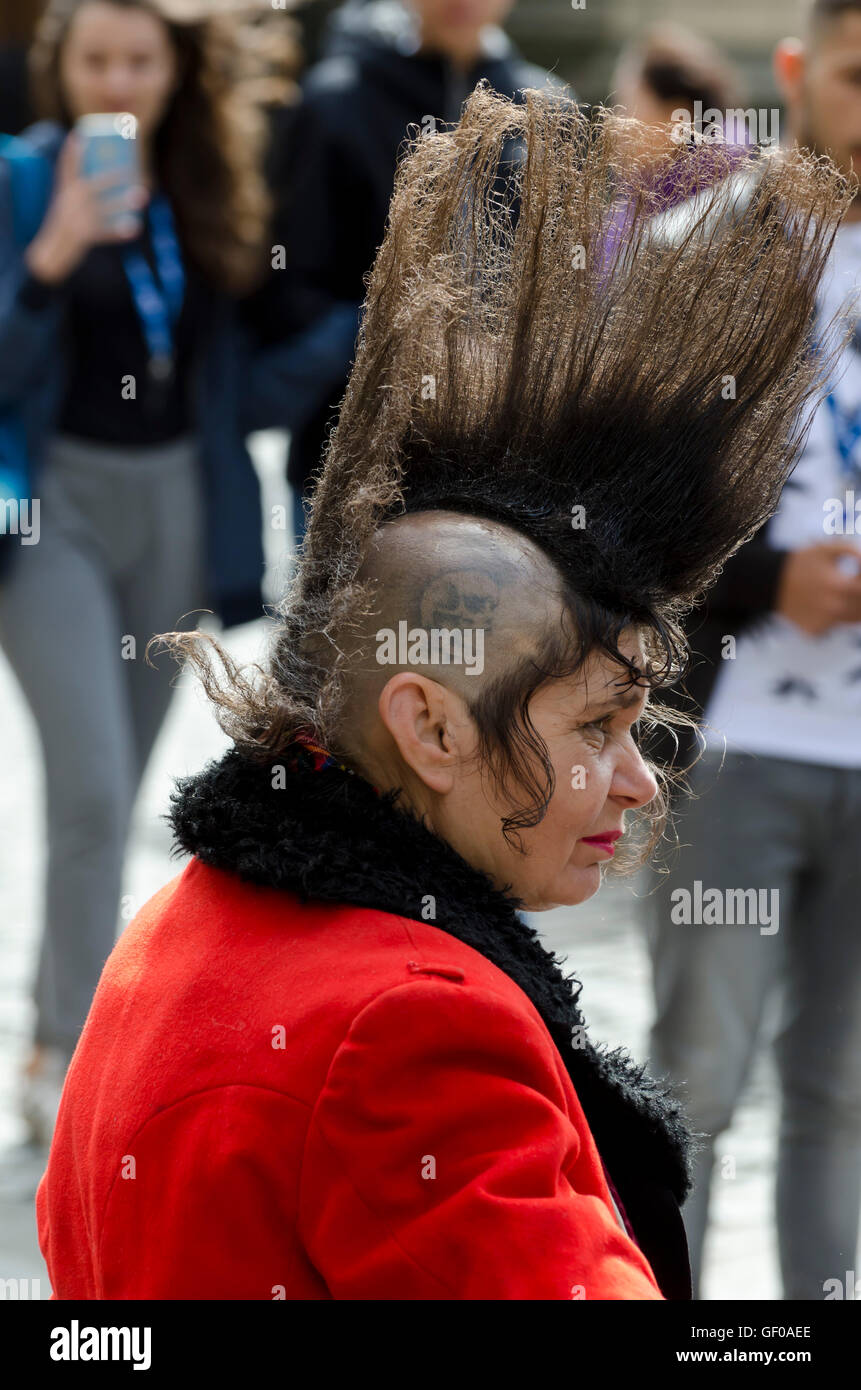 Middle-aged punk-style woman with a spinning wheel in the Royal Mile ...