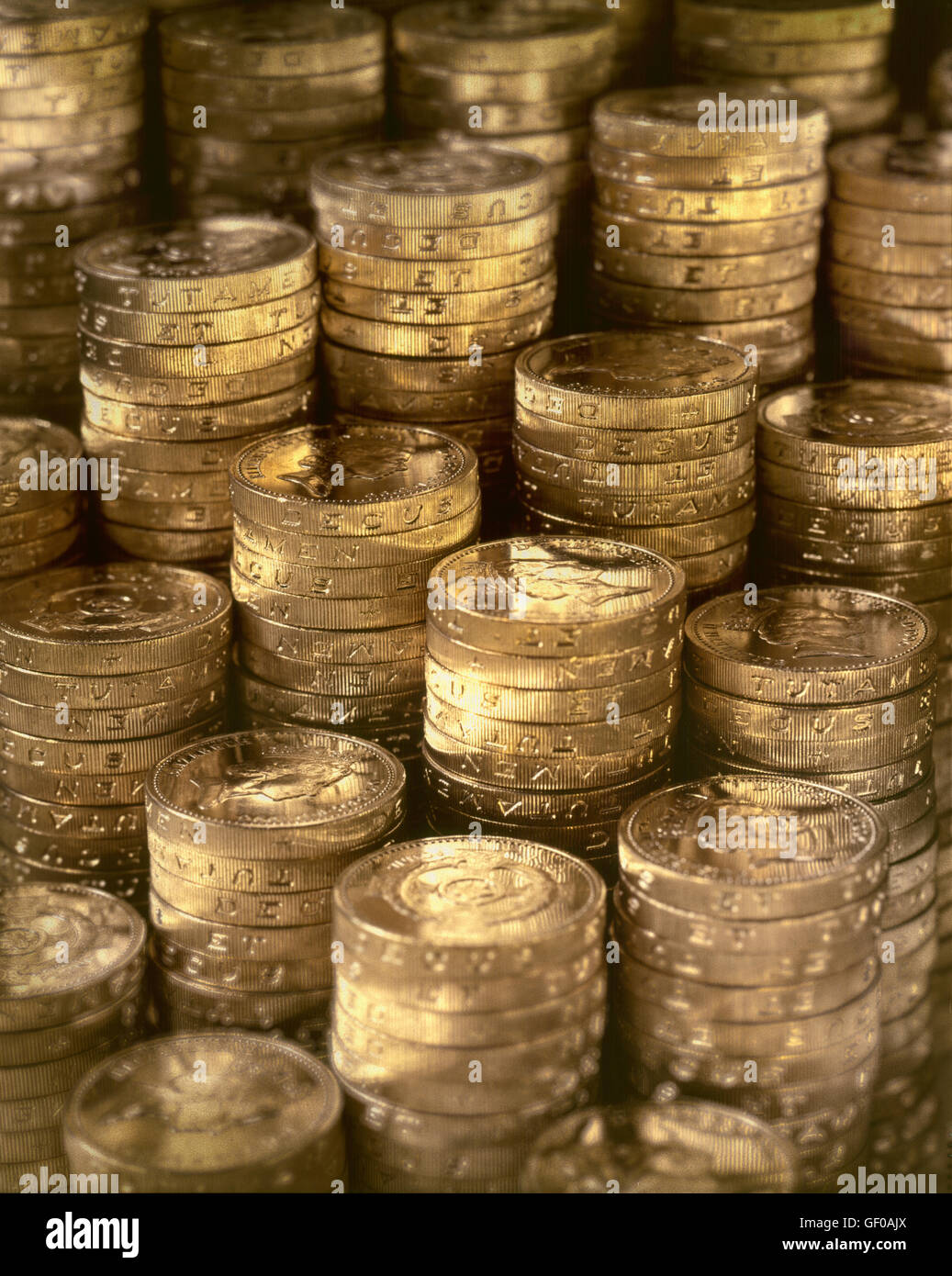 Many pound coins stacked on top of one another, shallow depth of field ...