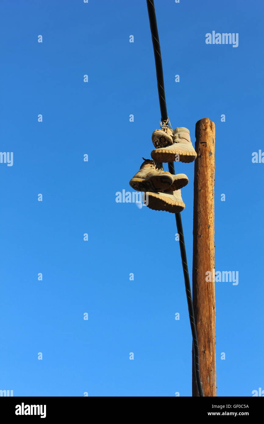 Two pairs of boots over wire Stock Photo - Alamy