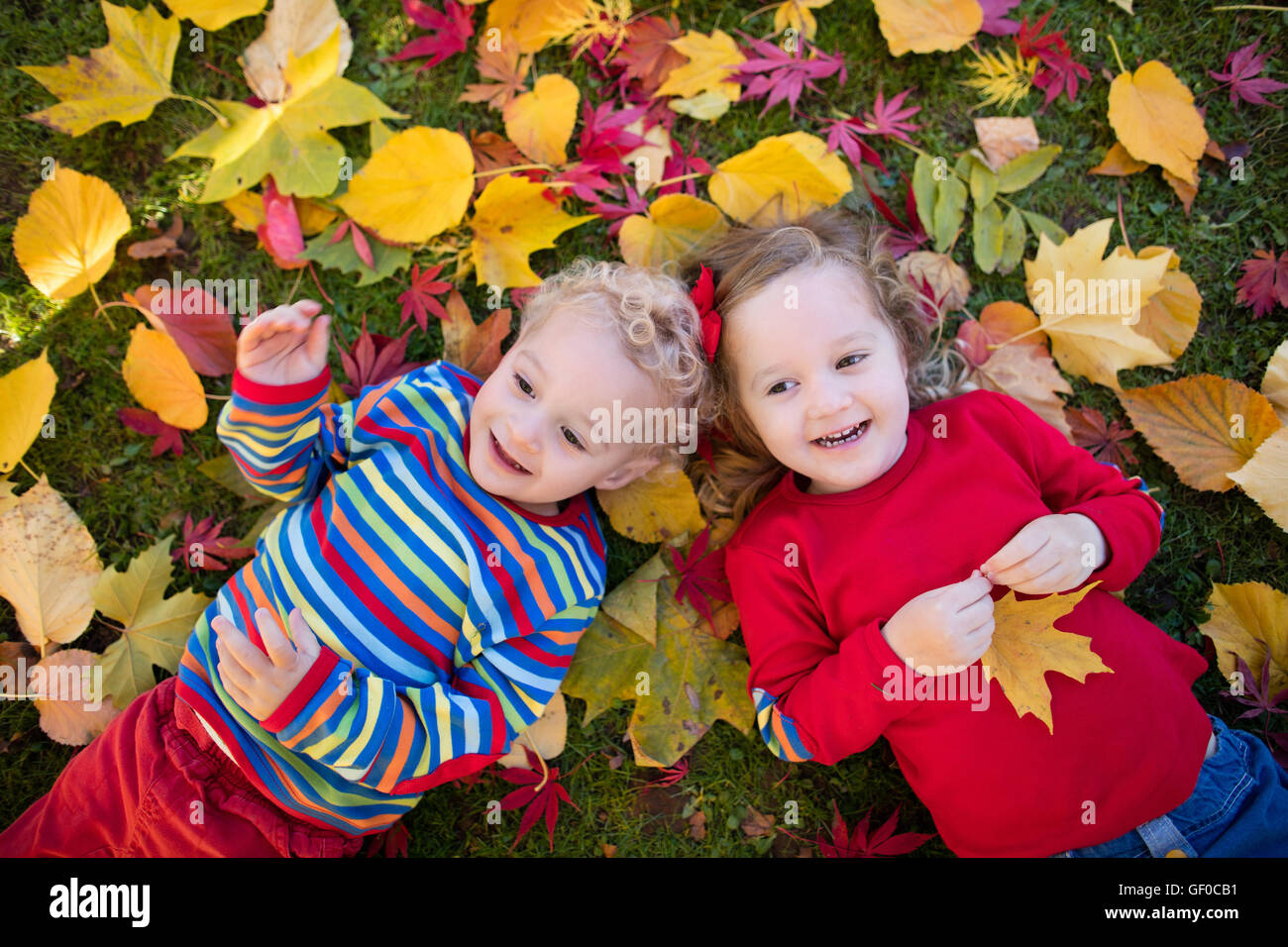 Happy children playing in beautiful autumn park on warm sunny fall day ...