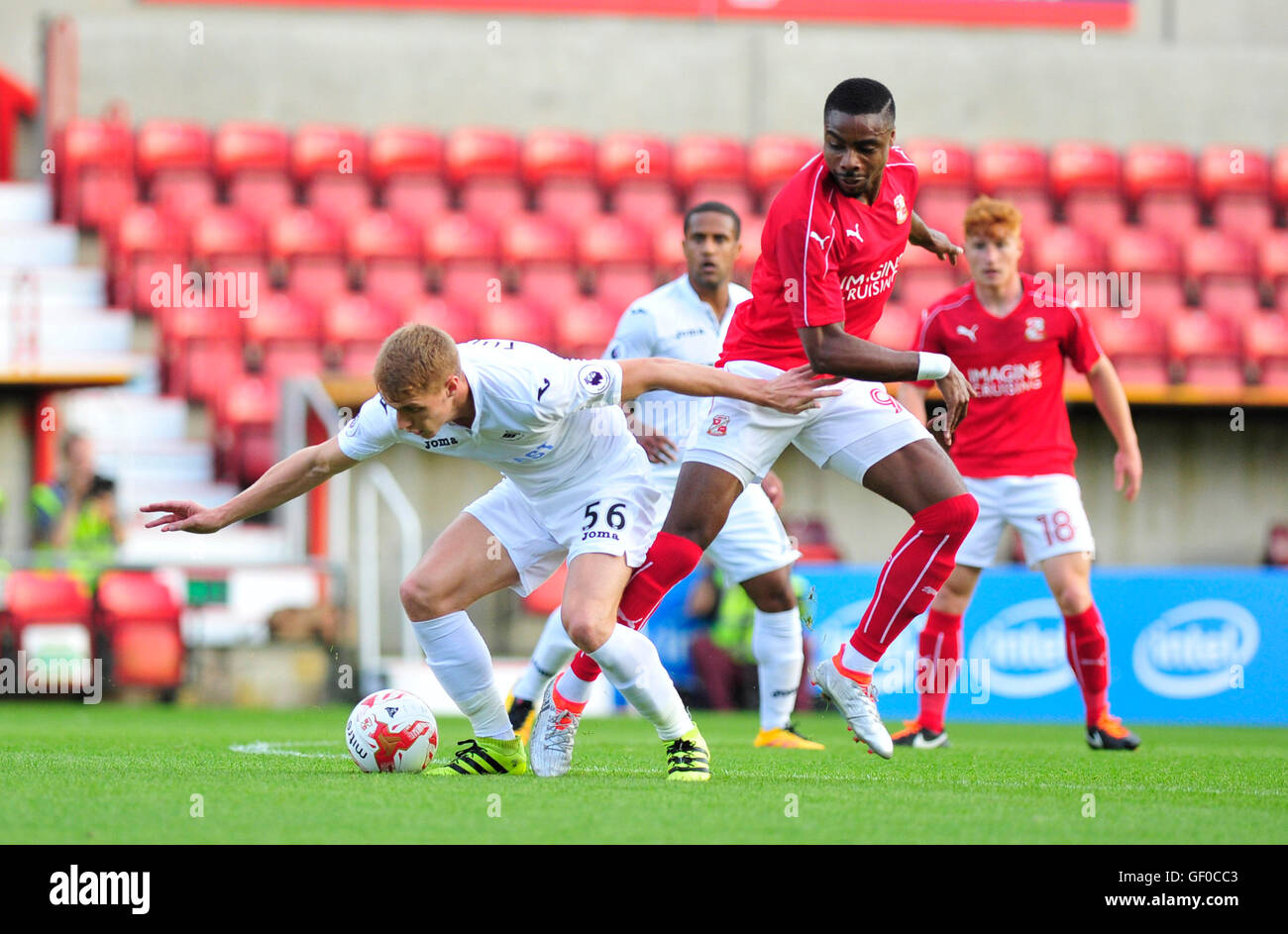 Swindon Town's Jon Obika and Swansea City's Jay Fulton battle for the ...