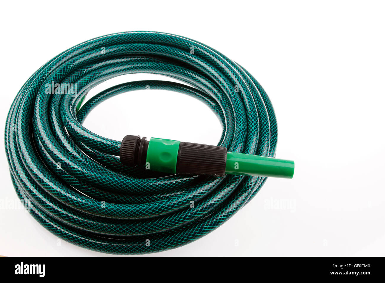Garden hose coiled on plain background Stock Photo - Alamy