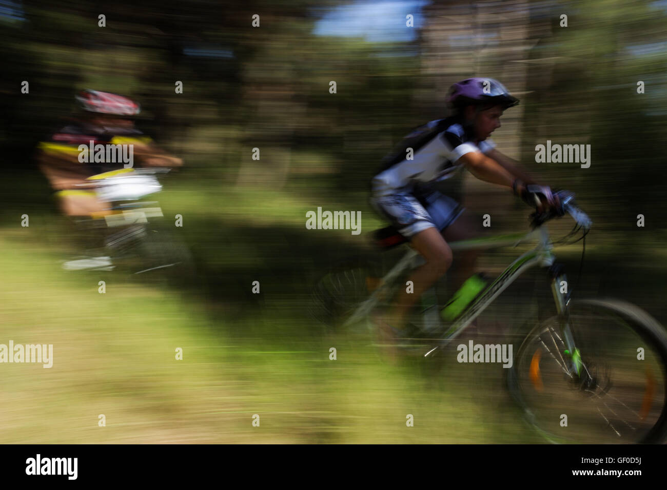Young MTB cyclists with camera motion panning blurry background light ...