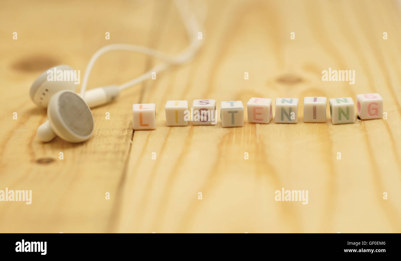 white earbuds with alphabet listening on cube shape Stock Photo - Alamy