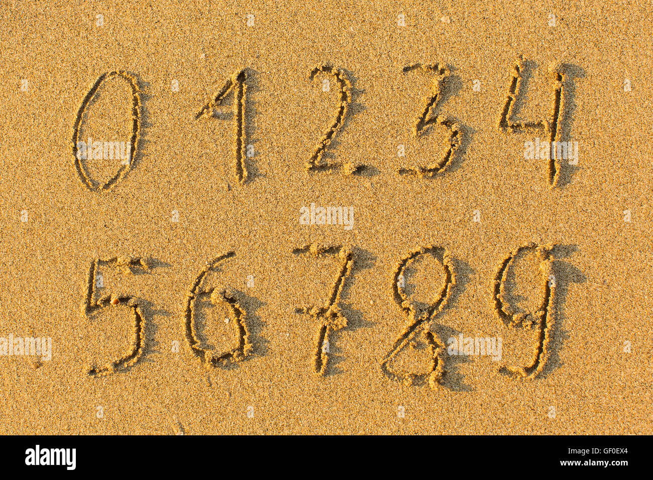 Numbers from 0 to 9 drawn on the sand to the sea Stock Photo - Alamy