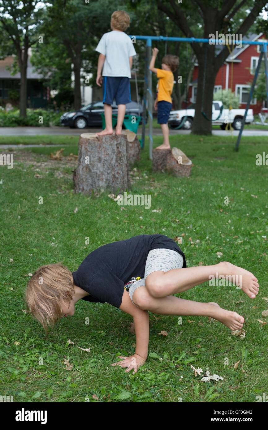 Three children playing in a yard Stock Photo - Alamy