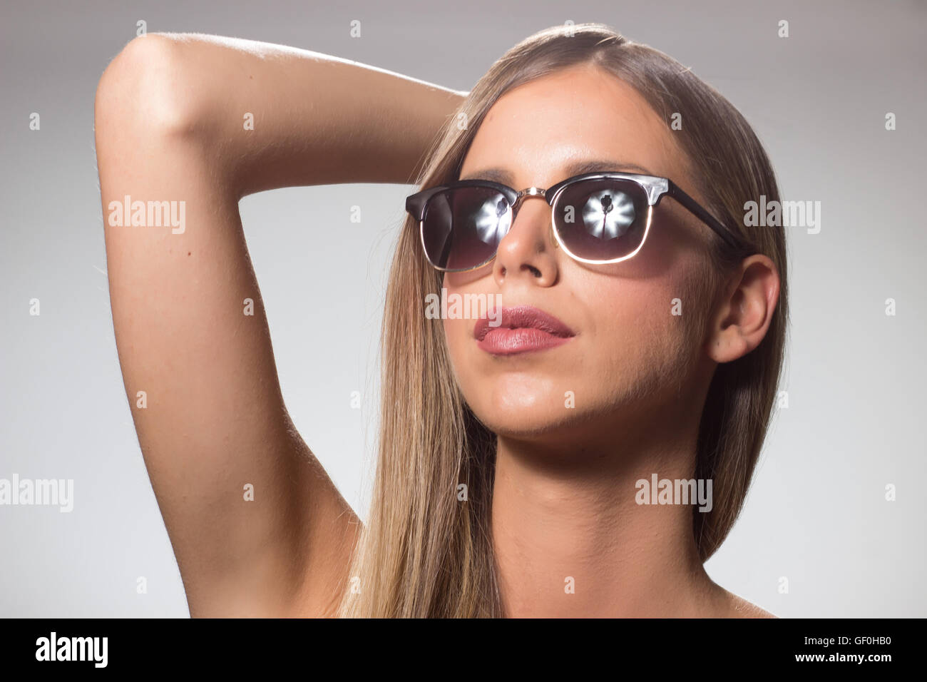 Young woman beauty sunglasses head arm up raised Stock Photo - Alamy