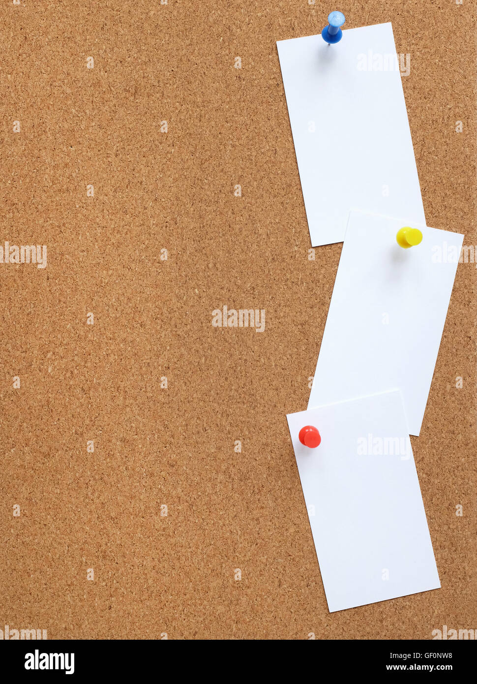 Vertical cork noticeboard with three white cards pinned vertically down ...