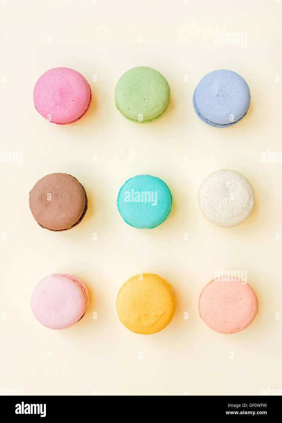 Sweet colorful French macaroon biscuits on pastel yellow background ...