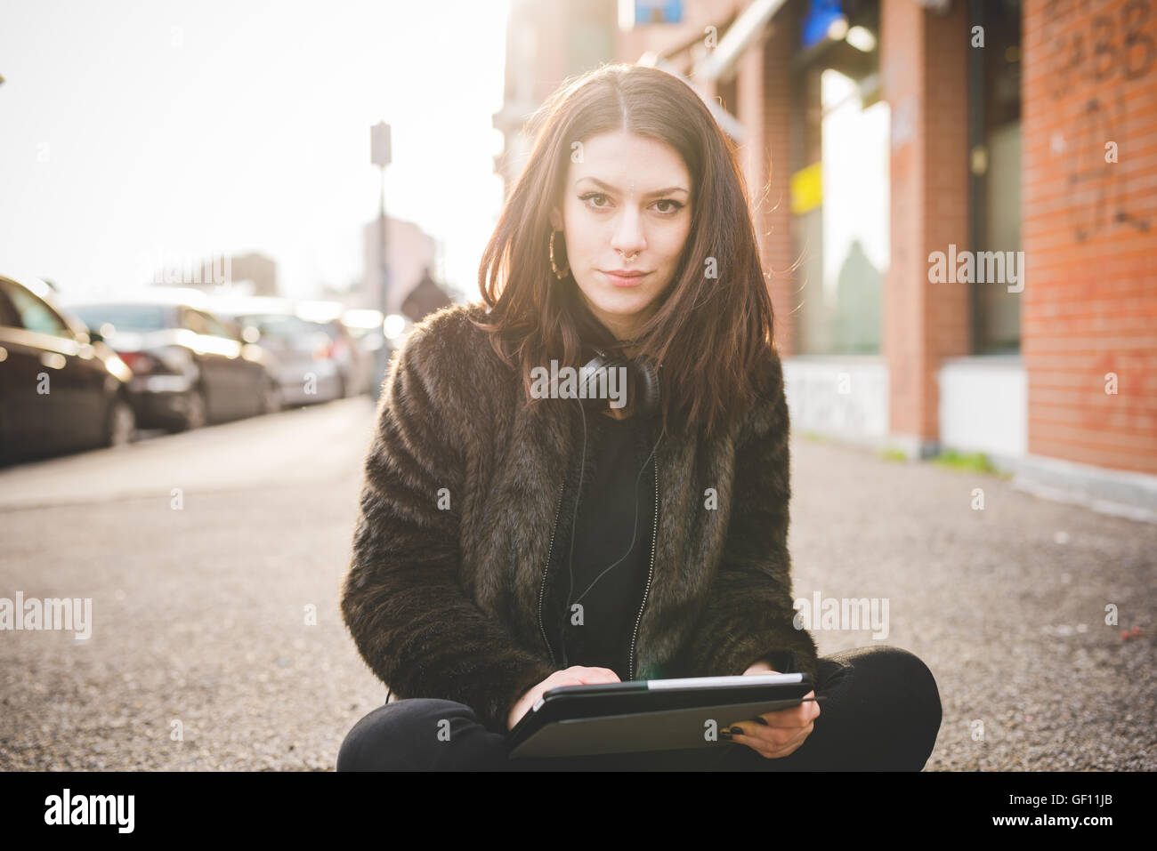 Young beautiful caucasian indie woman with septum piercing using tablet ...
