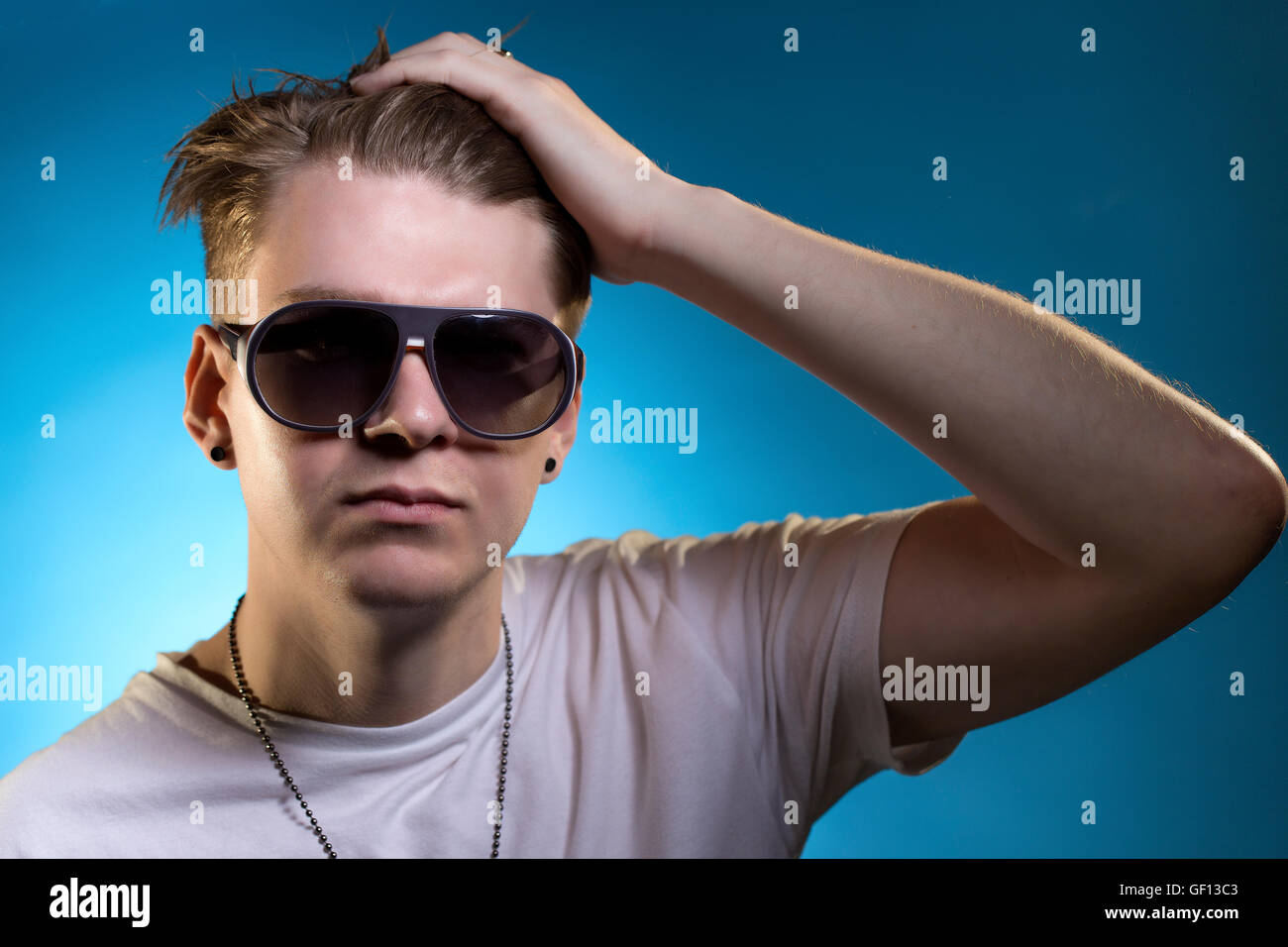 Male model portrait, sunglasses, hair, styling, blue background ...