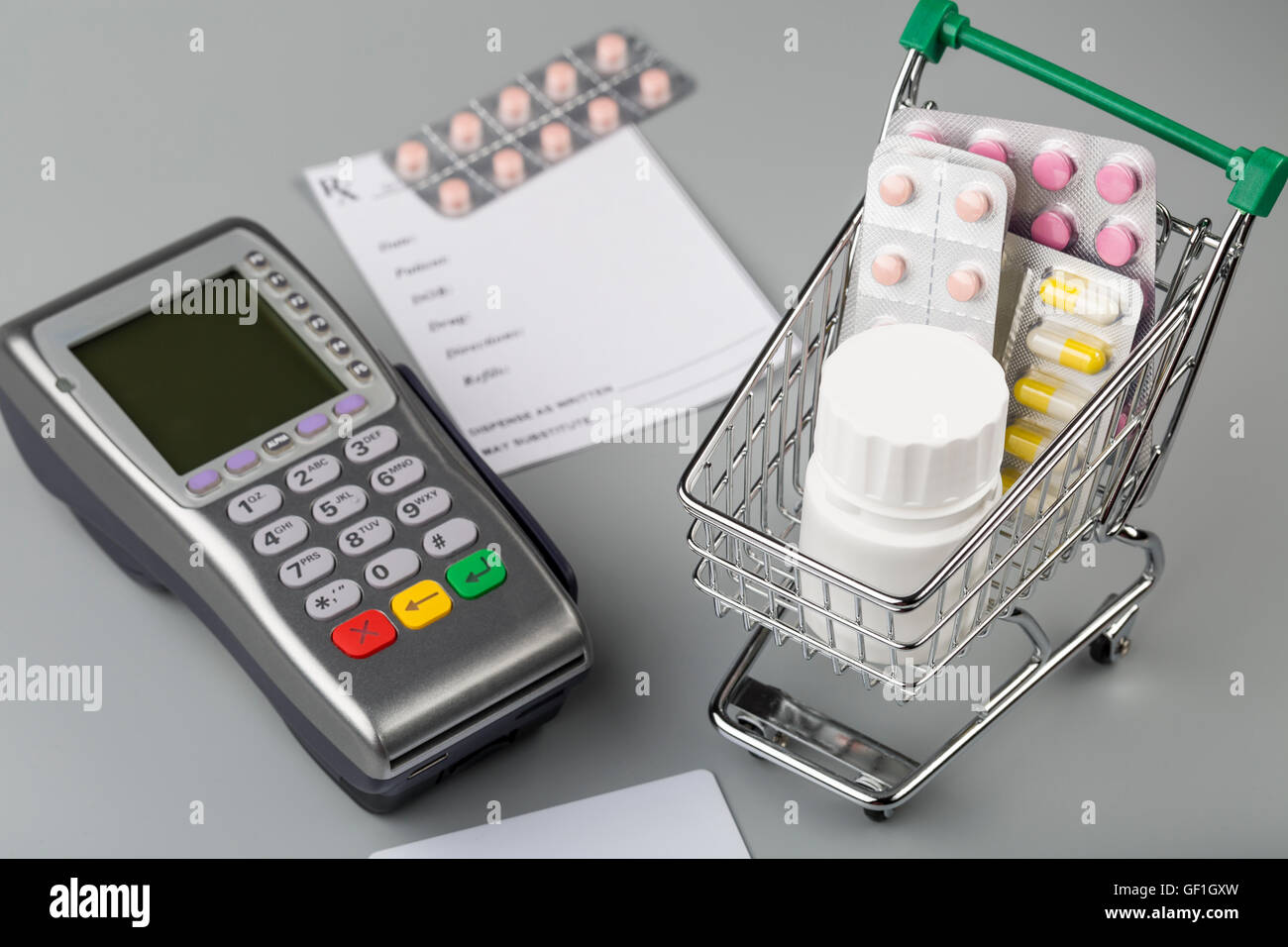 Pos terminal and shopping cart full of various pills Stock Photo - Alamy