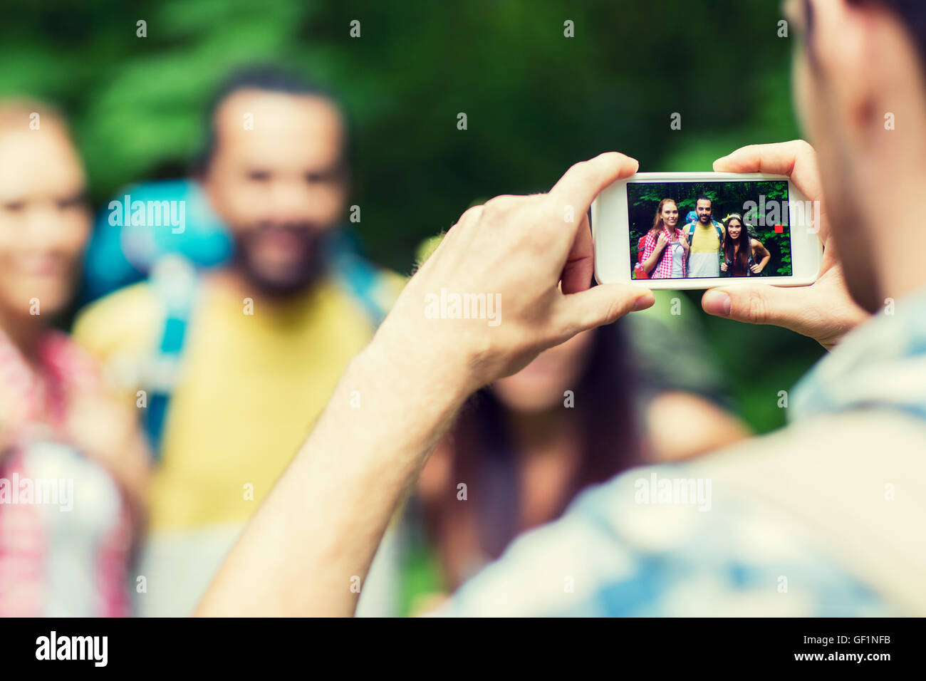 man photographing friends by smartphone Stock Photo - Alamy