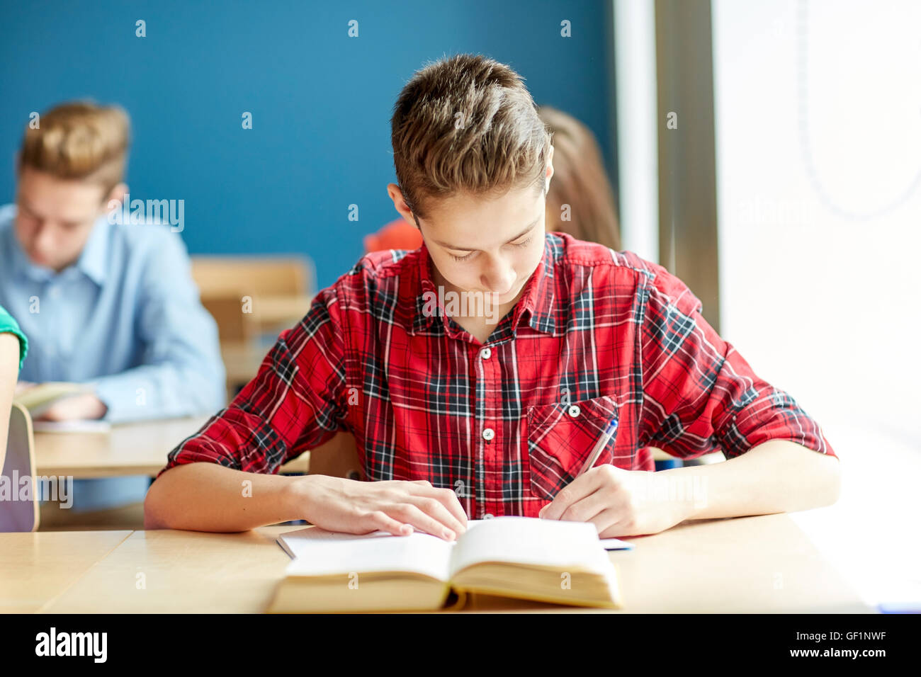 group of students with books writing school test Stock Photo - Alamy