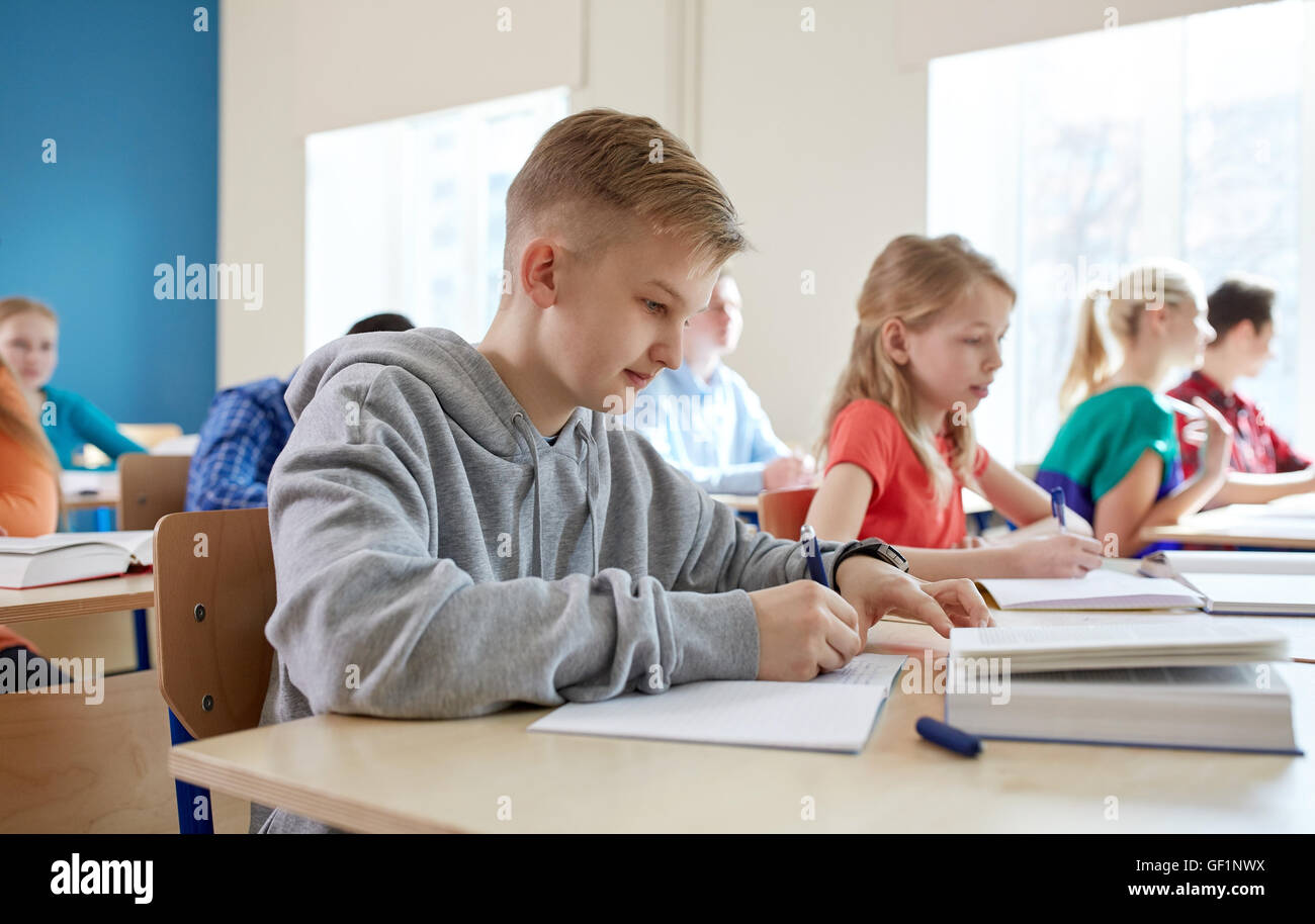 group of students with books writing school test Stock Photo - Alamy