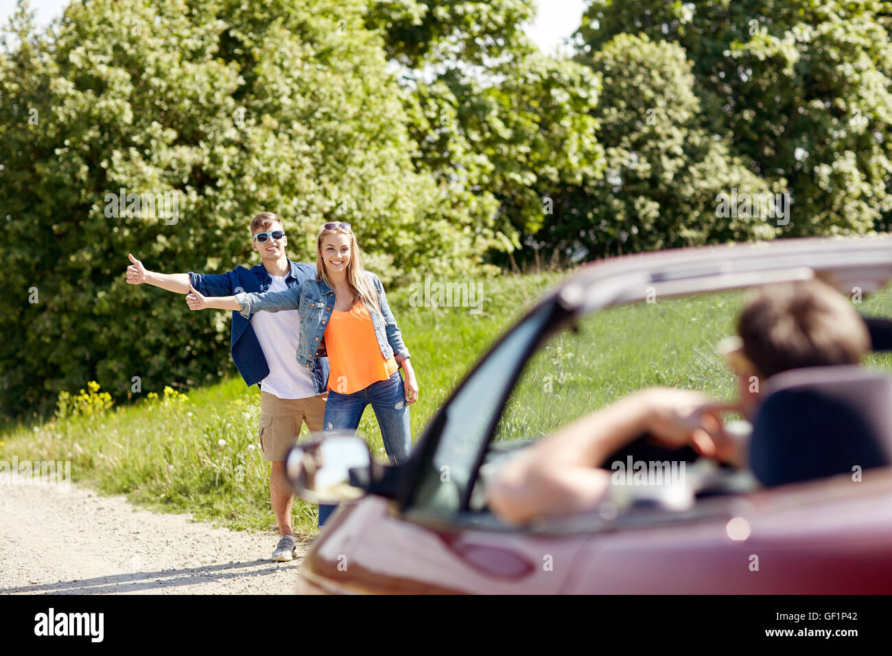 couple hitchhiking and stopping car on countryside Stock Photo - Alamy