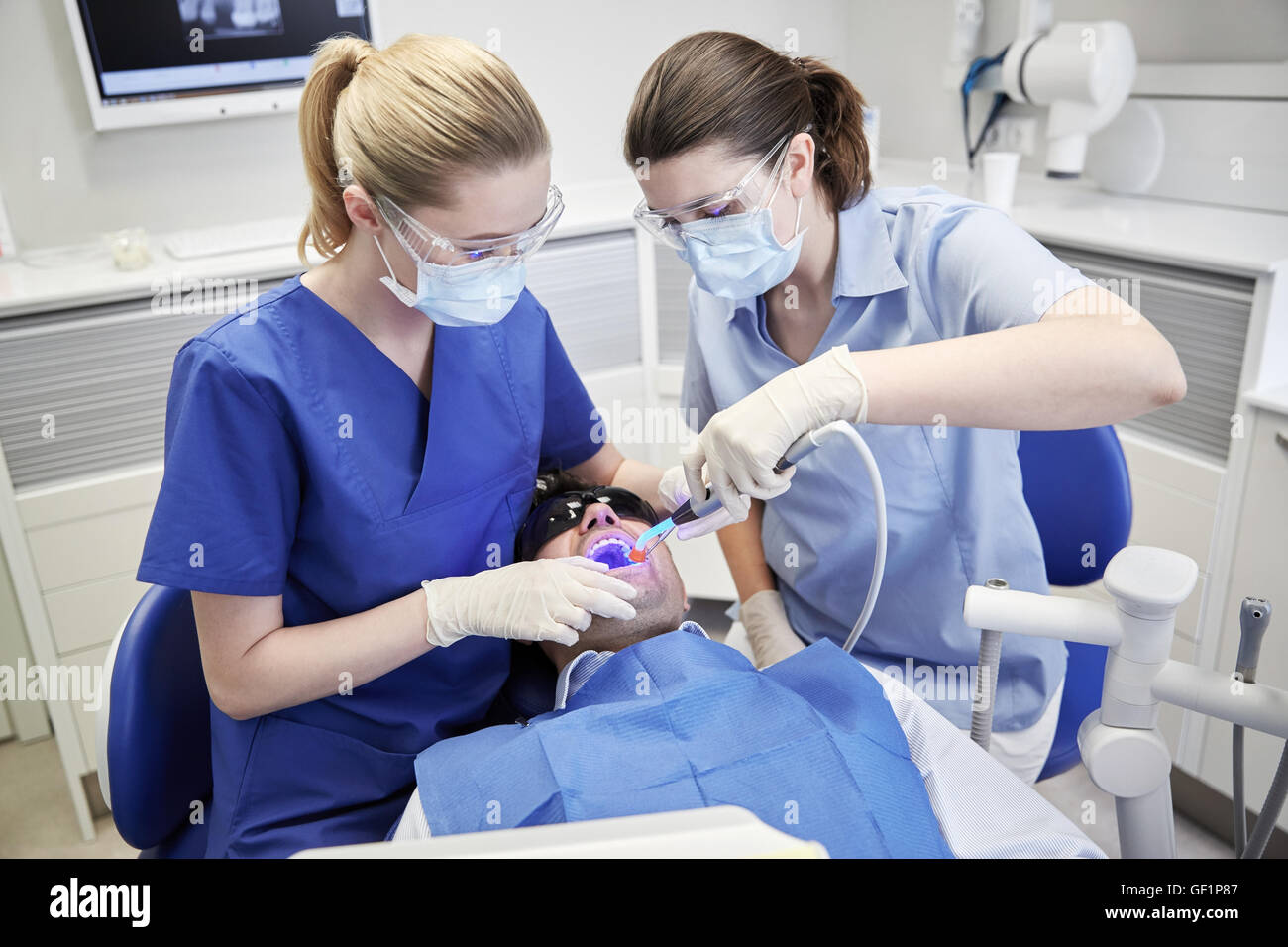 dentists treating male patient teeth at clinic Stock Photo - Alamy