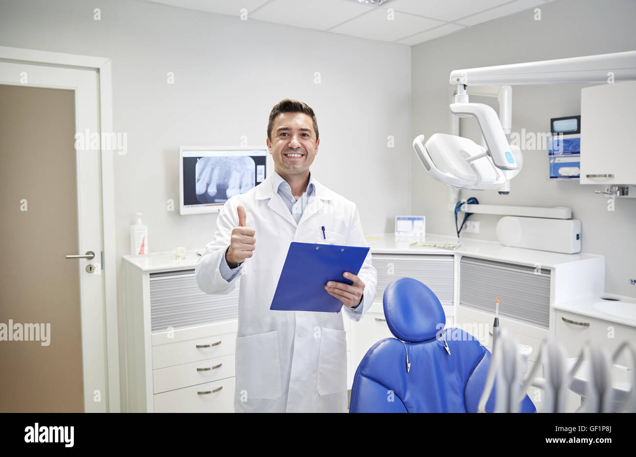 happy male dentist showing thumbs up at clinic Stock Photo - Alamy