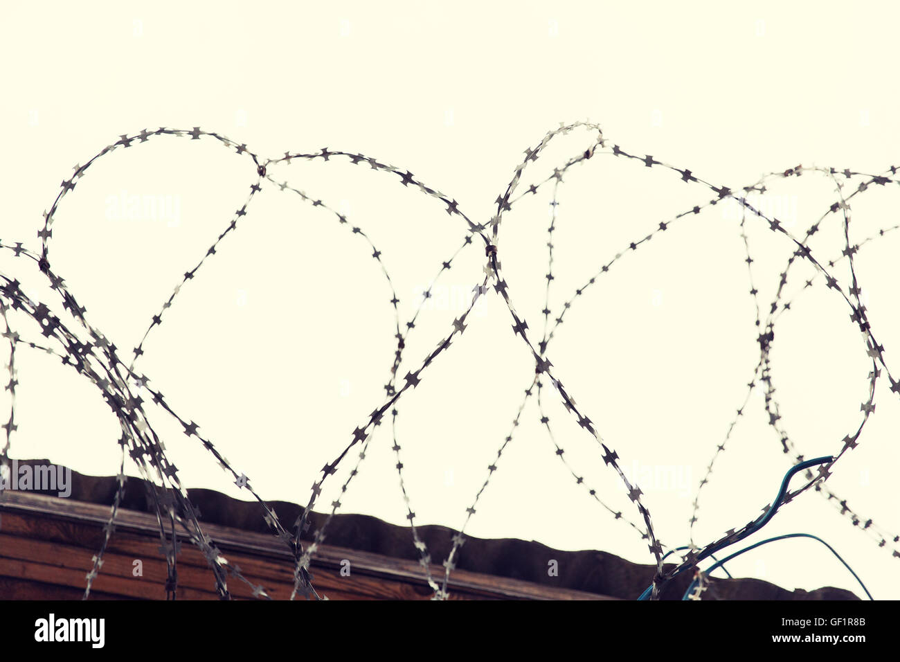 barb wire fence over gray sky Stock Photo - Alamy