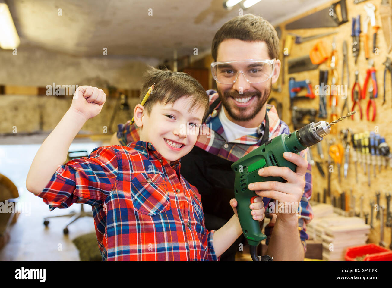 father and son with drill working at workshop Stock Photo - Alamy