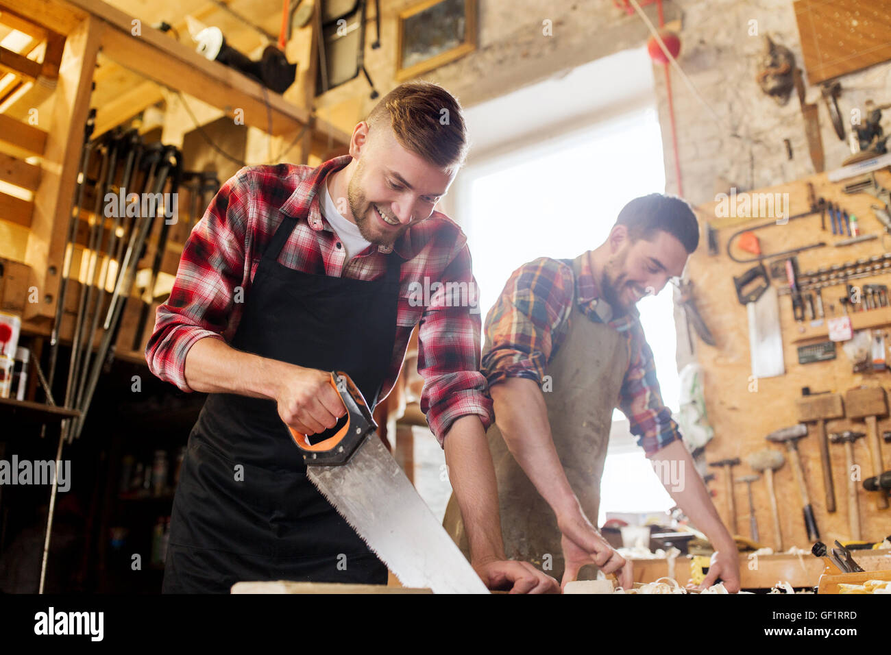 carpenters working with saw and wood at workshop Stock Photo - Alamy