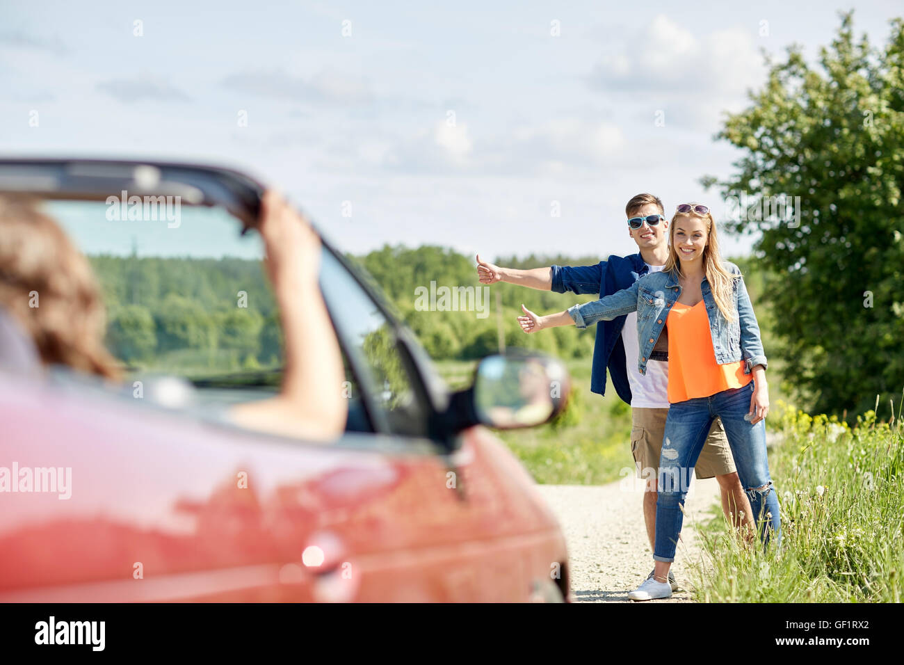 couple hitchhiking and stopping car on countryside Stock Photo - Alamy