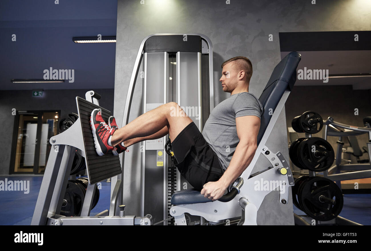 man flexing leg muscles on gym machine Stock Photo - Alamy