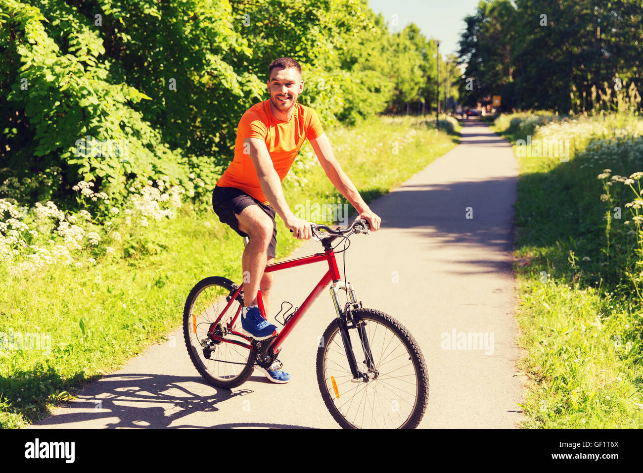 happy young man riding bicycle outdoors Stock Photo - Alamy