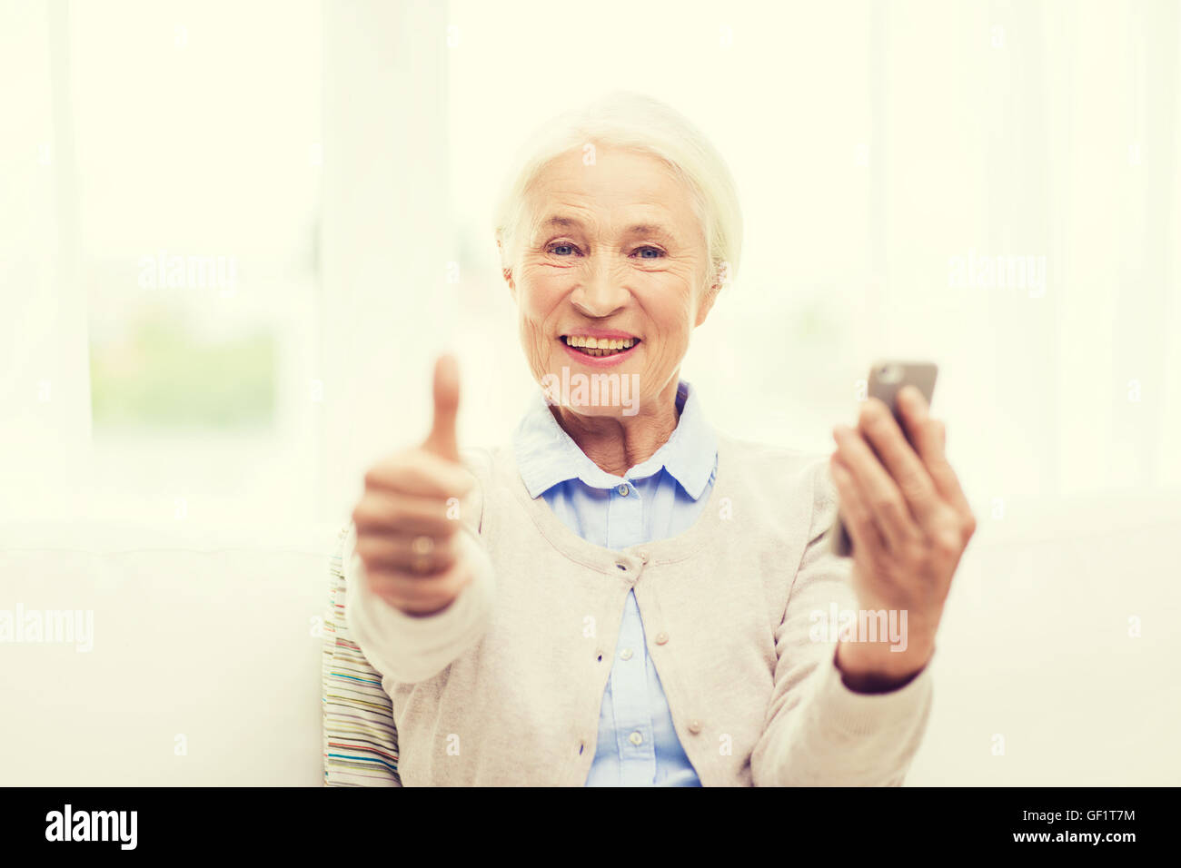 Person showing thumbs up with mobile hi-res stock photography and ...