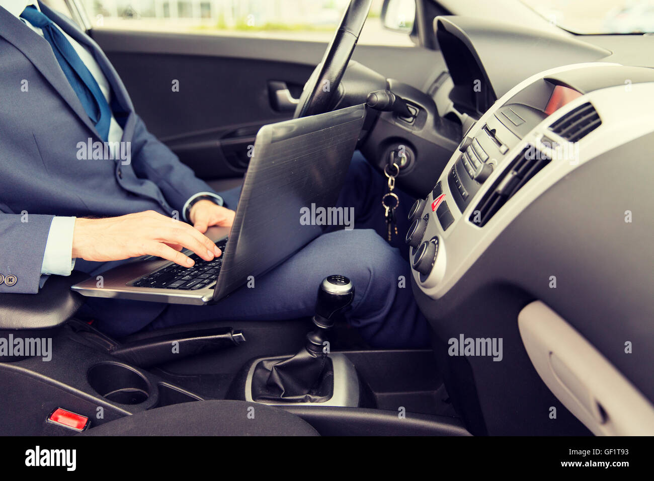 close up of young man with laptop driving car Stock Photo - Alamy