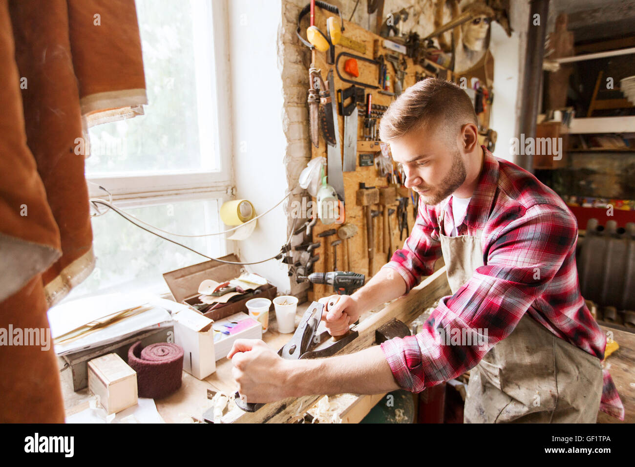 carpenter working with plane and wood at workshop Stock Photo - Alamy