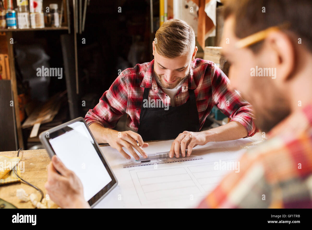 workmen with tablet pc and blueprint at workshop Stock Photo - Alamy