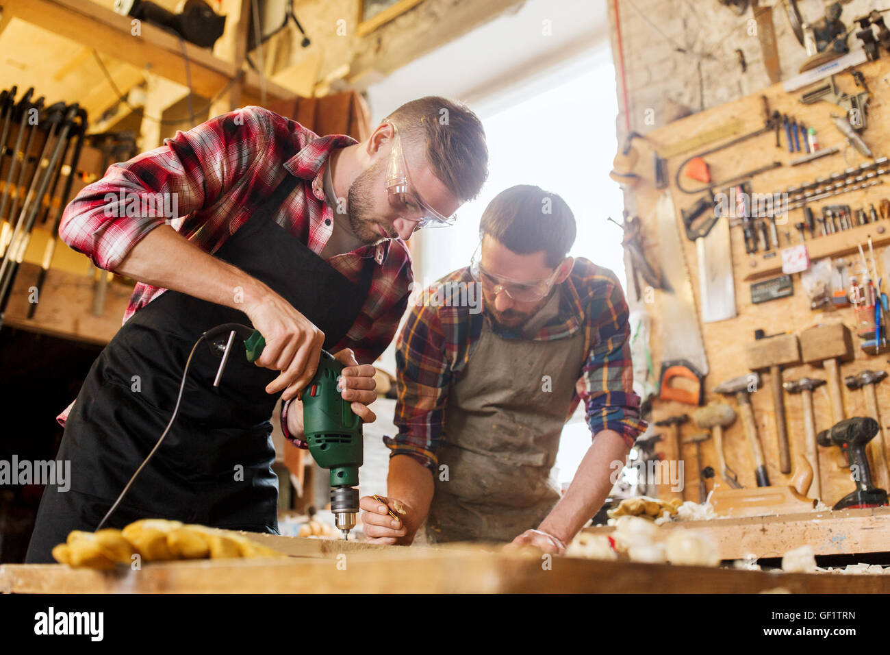 carpenters with drill drilling plank at workshop Stock Photo - Alamy