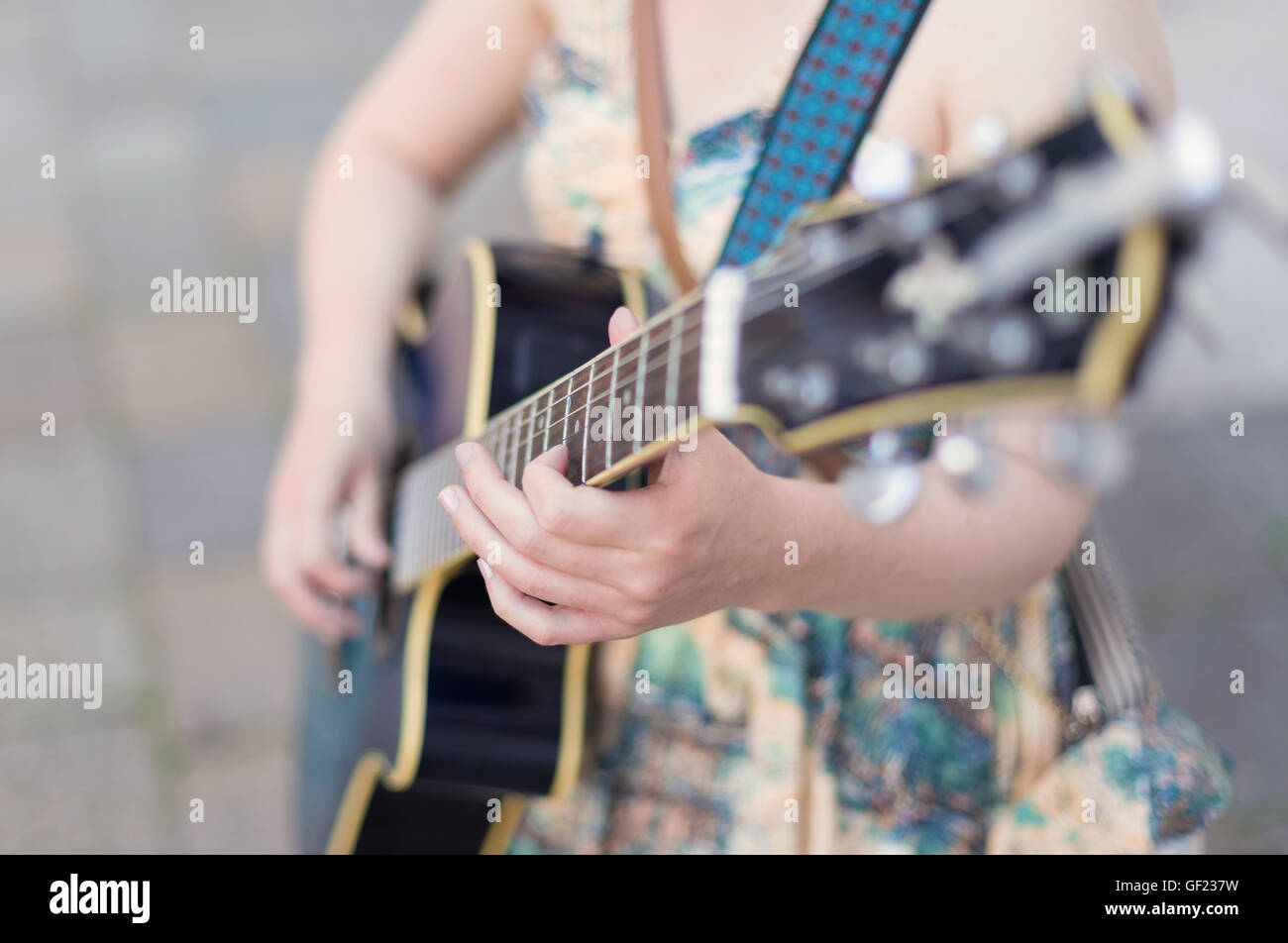 Female street musician playing guitar Stock Photo - Alamy