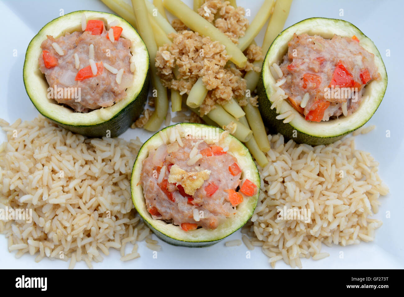 Courgette stuffed with minced meat, rice and french bean on white plate ...