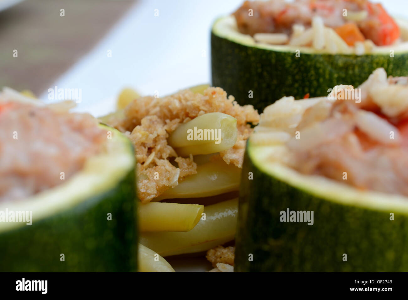 Courgette stuffed with minced meat, rice and french bean on white plate ...