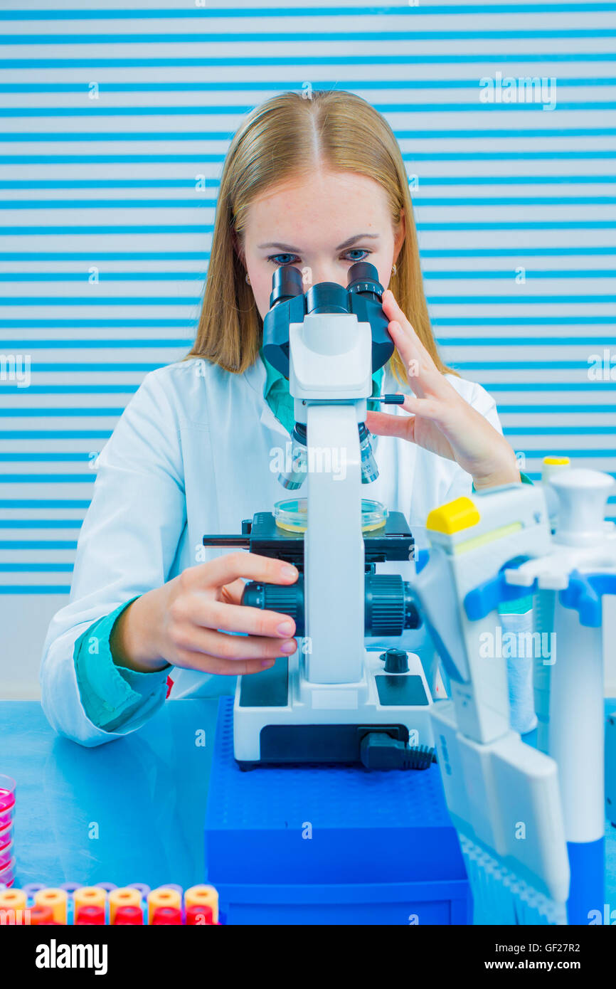Female scientist looking through a microscope in laboratory Stock Photo ...
