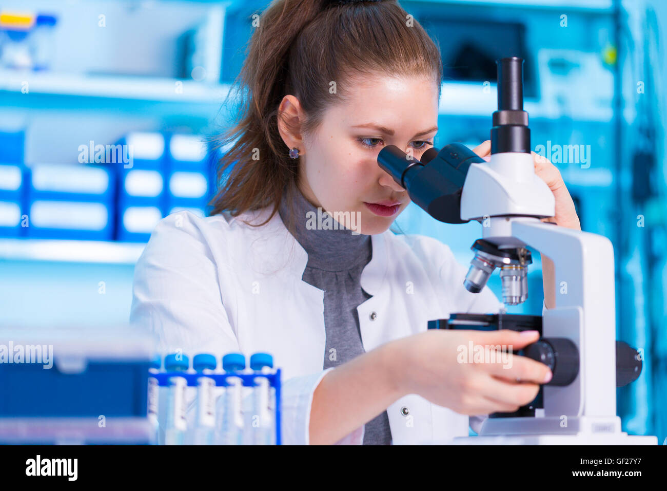 Female scientist looking through a microscope in laboratory Stock Photo ...