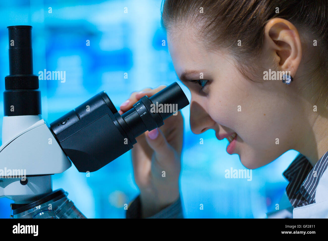 Female scientist looking through a microscope in laboratory Stock Photo ...